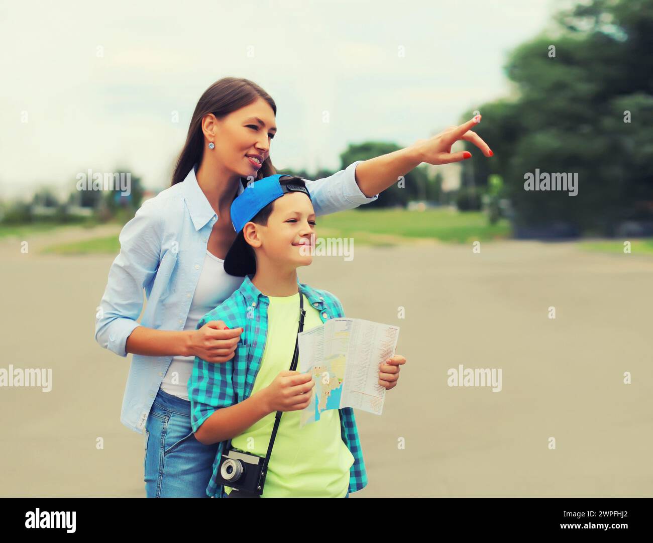Happy mother with child son tourists sightseeing city with paper map ...