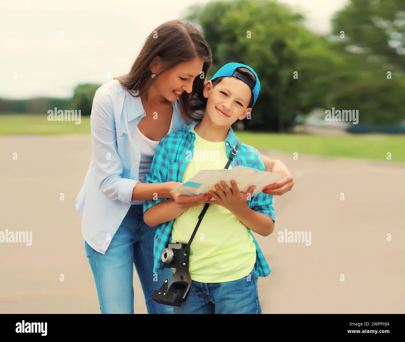 Happy mother with child son tourists sightseeing city with paper map ...