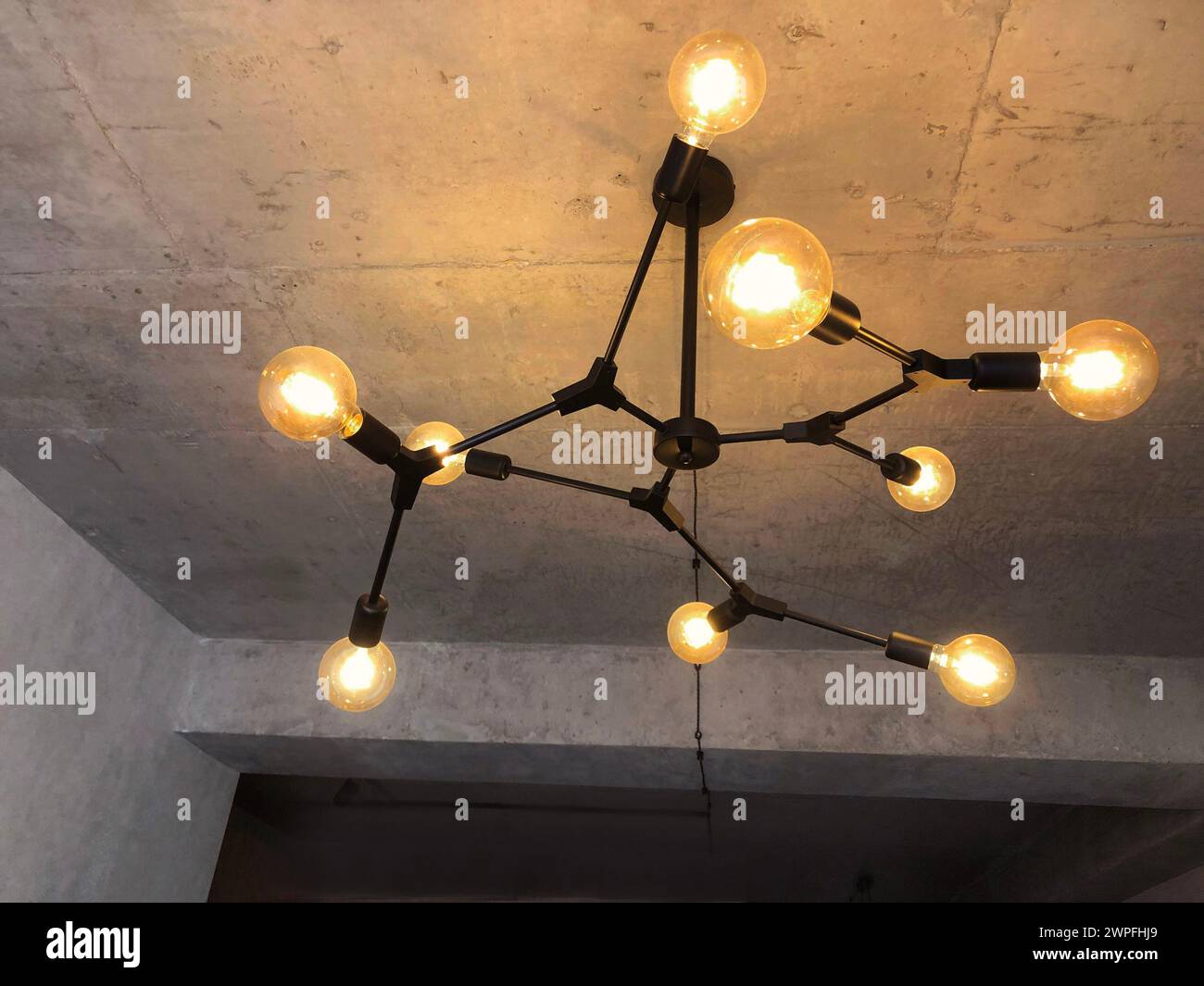 Light bulbs with warm lighting in stylish chandelier with exposed ...