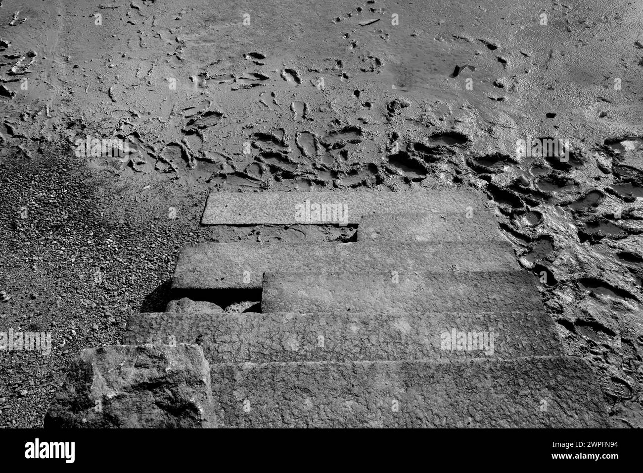 Monochrome shot in strong sunlight of concrete steps and footprints in ...