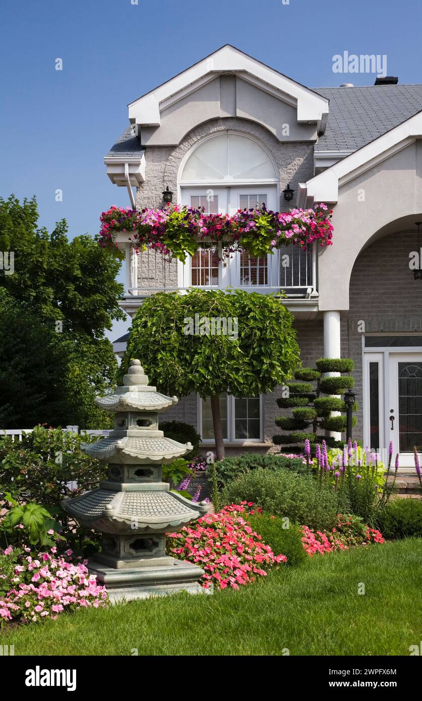 Grey brick with white trim two story home with pink and red Impatiens ...