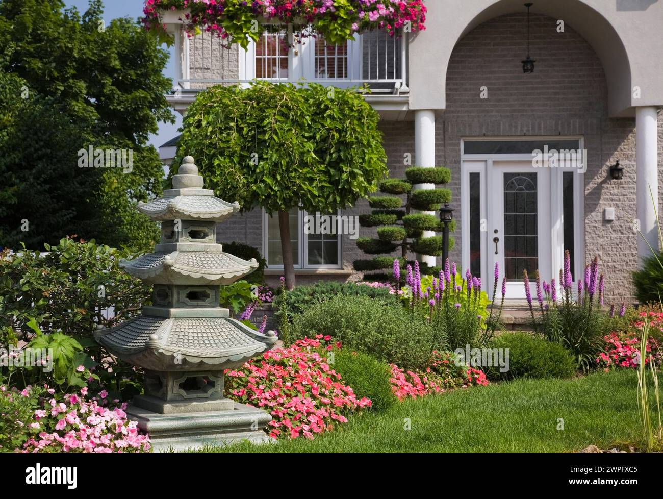 Grey brick with white trim two story home with pink and red Impatiens ...