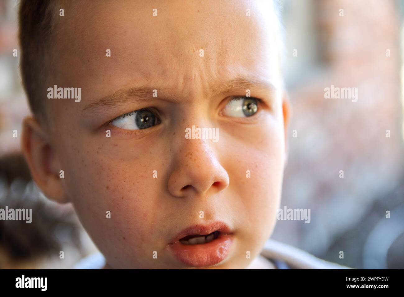 A young boy with a furrowed brow shows a confused, indignant ...
