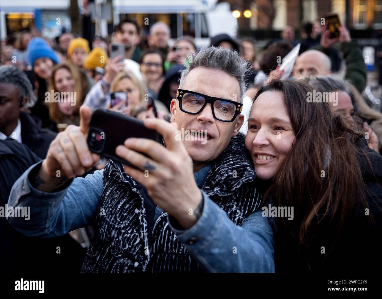 AMSTERDAM - Robbie Williams takes a selfie with fans prior to the ...