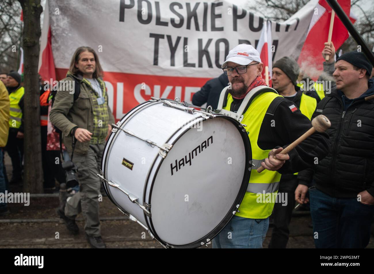 A protester seen marching while drumming during the demonstration ...