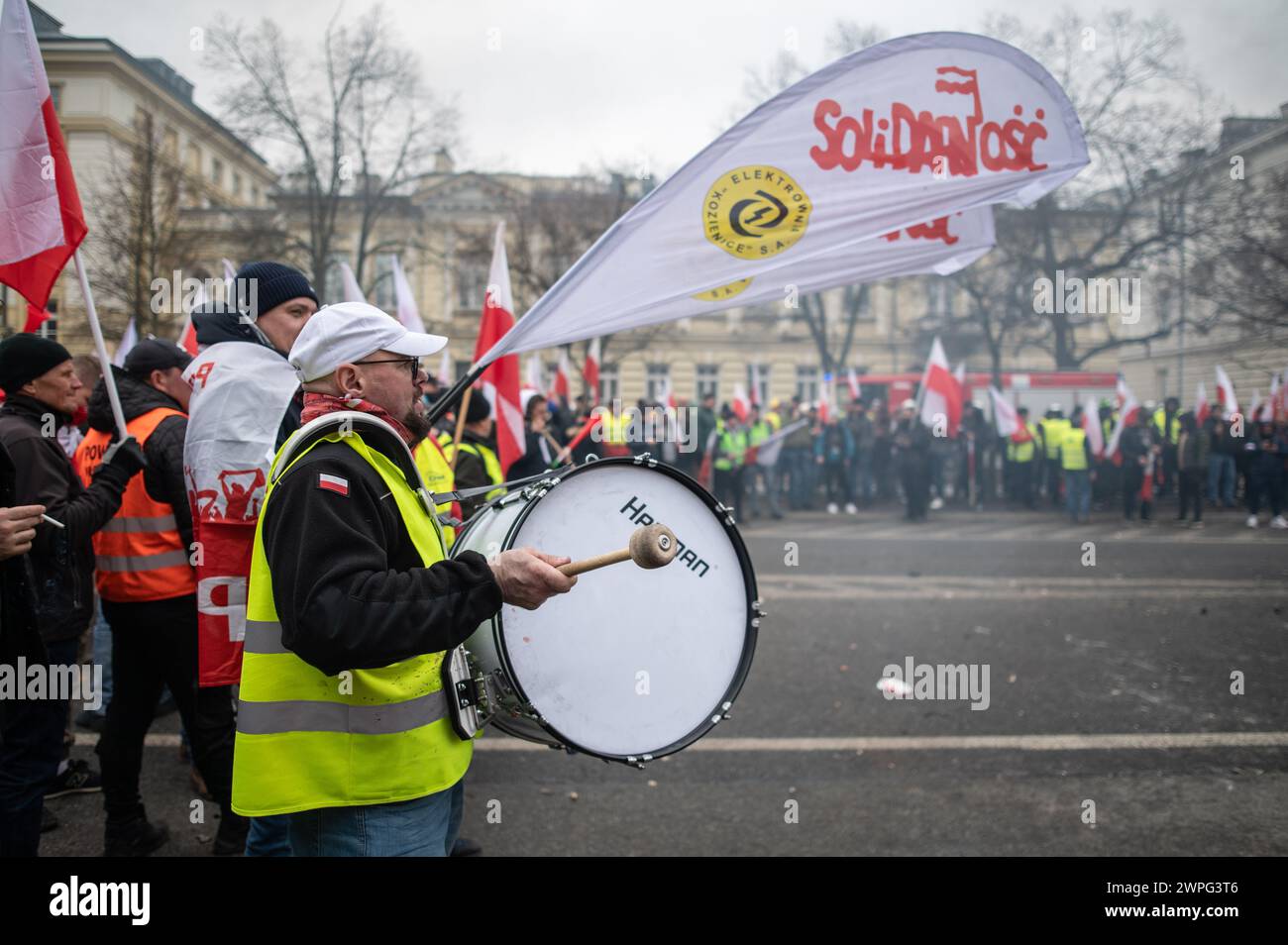A protester seen marching while drumming during the demonstration ...