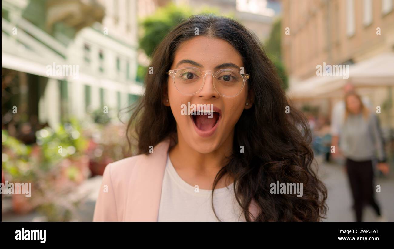 Young surprised amazed excited woman Indian Arabian female girl outside ...