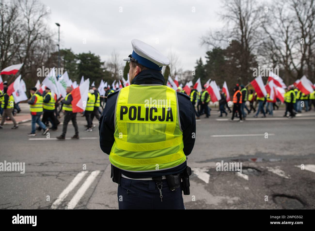 March 6, 2024, Warsaw, Poland: A policeman monitors protesters marching ...