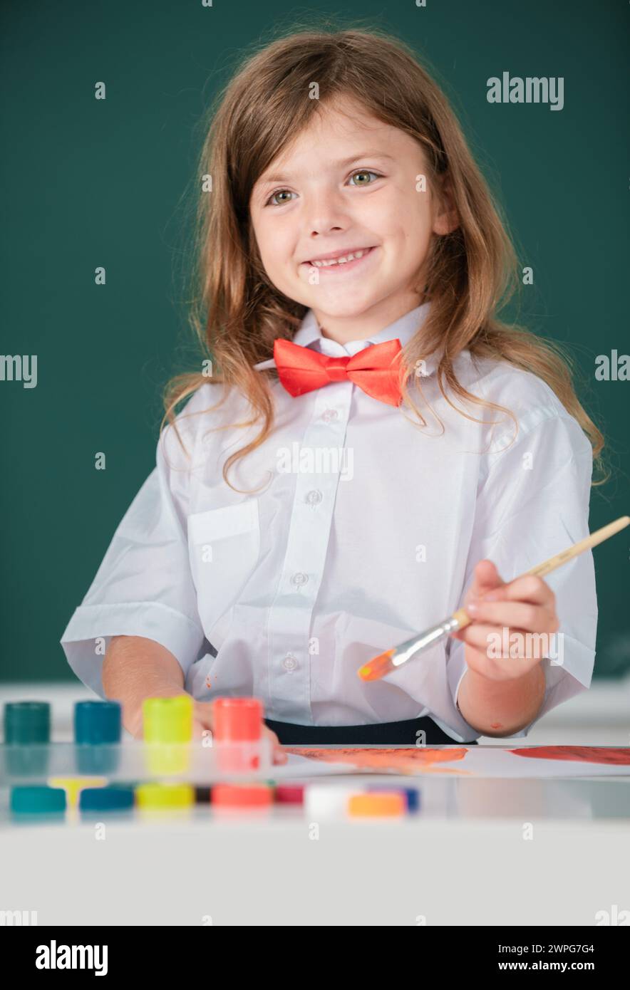 Portrait of little girl smiling happily while enjoying art and craft ...