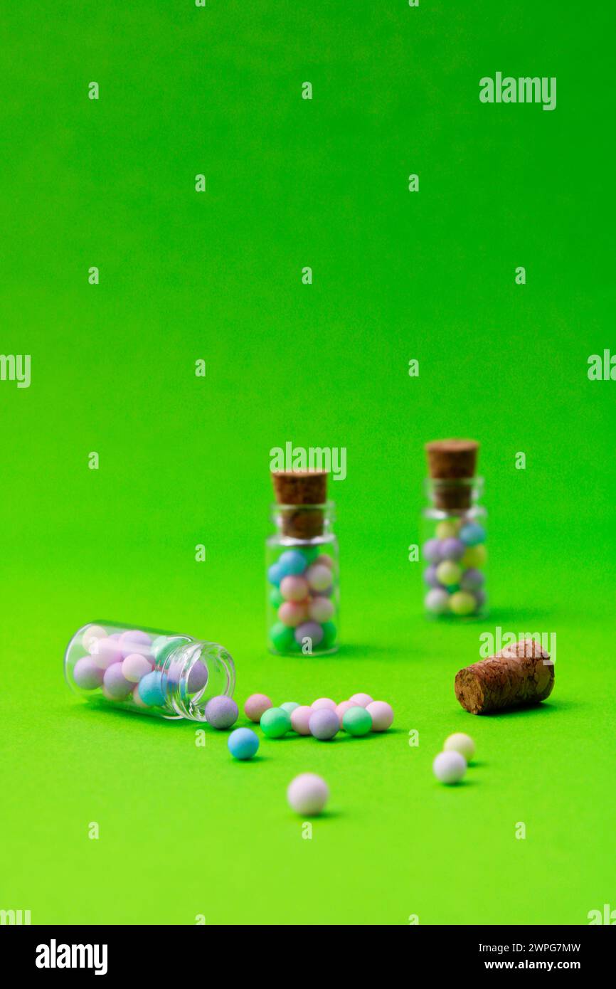 Three glass jars where one of them is open and colorful spheres coming ...