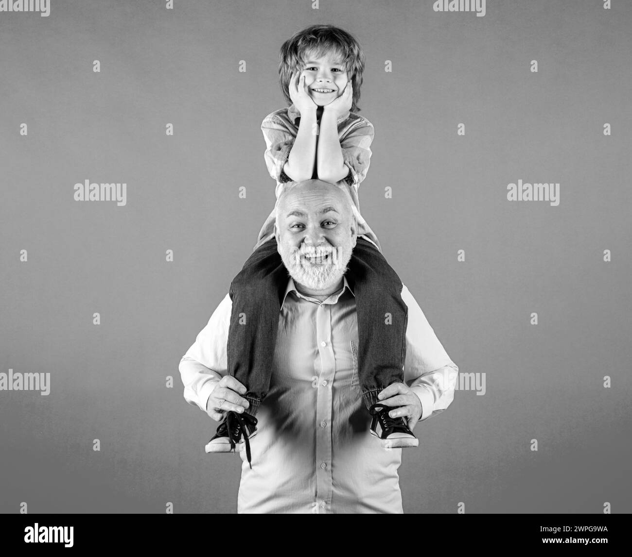 Old grandfather and young child grandson piggyback ride with funny face ...