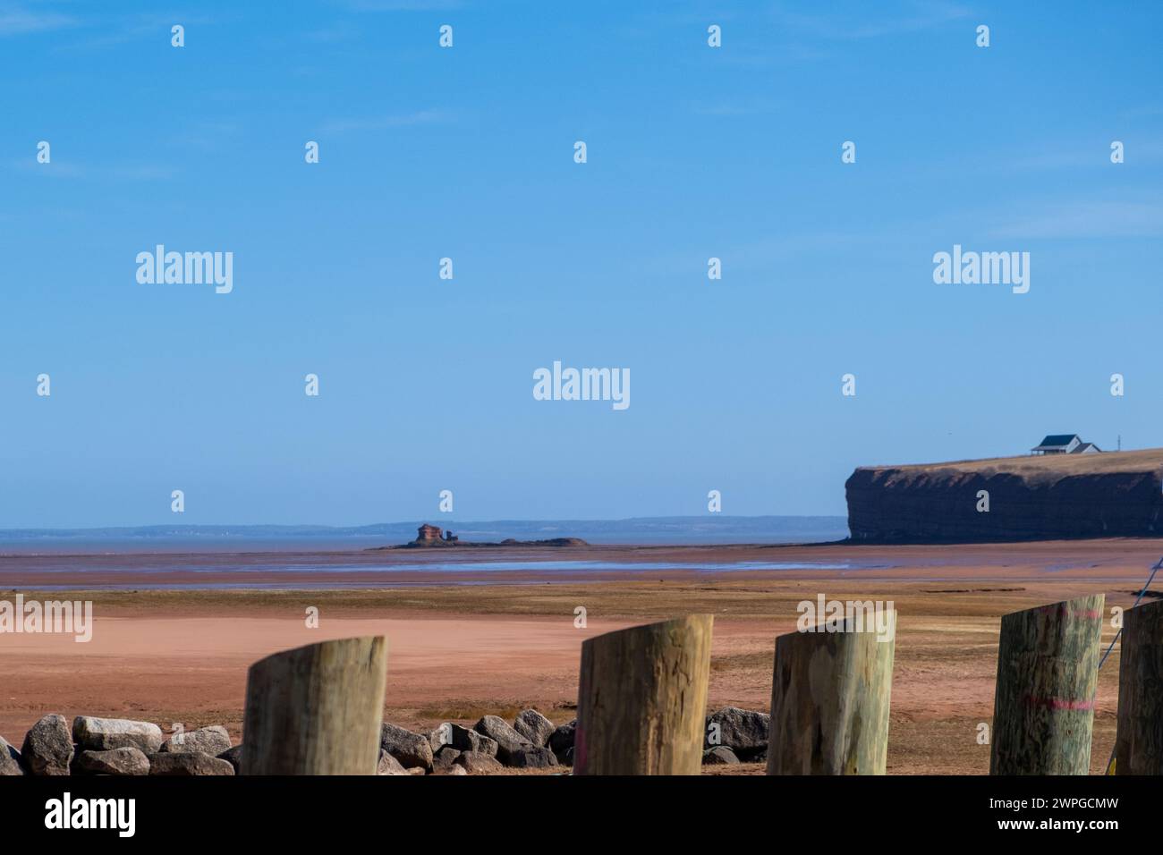 Blomidon at Low tide showing sandy beach and tidal pools with red clif ...