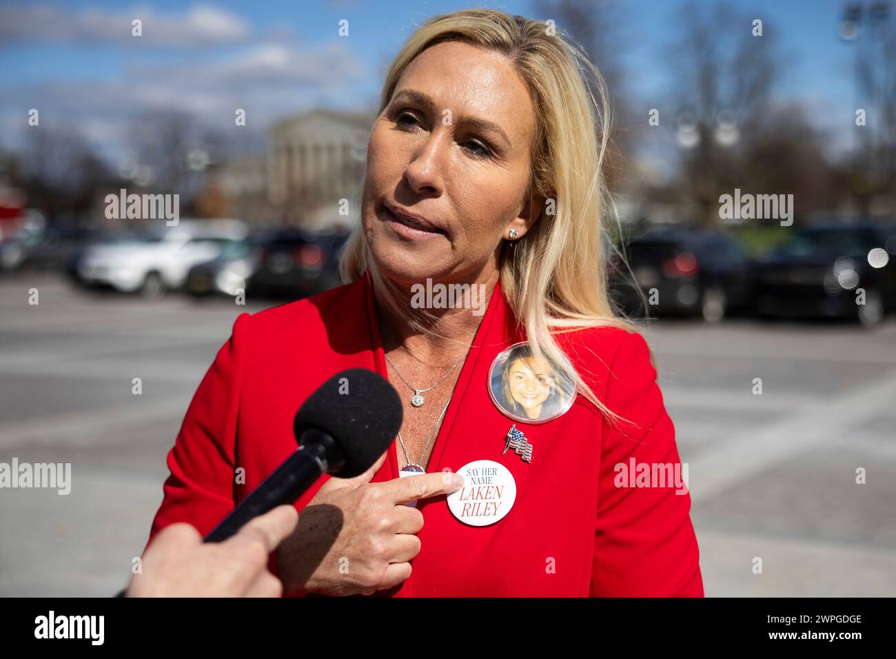 Rep. Marjorie Taylor Greene (R-Ga.) points to a pin with the name of ...