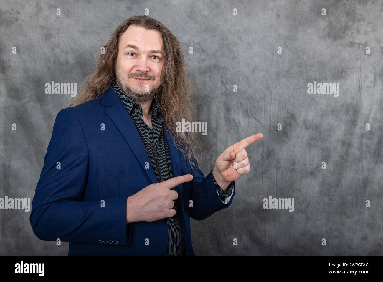 Suave man with long hair in sleek blue suit striking different ...