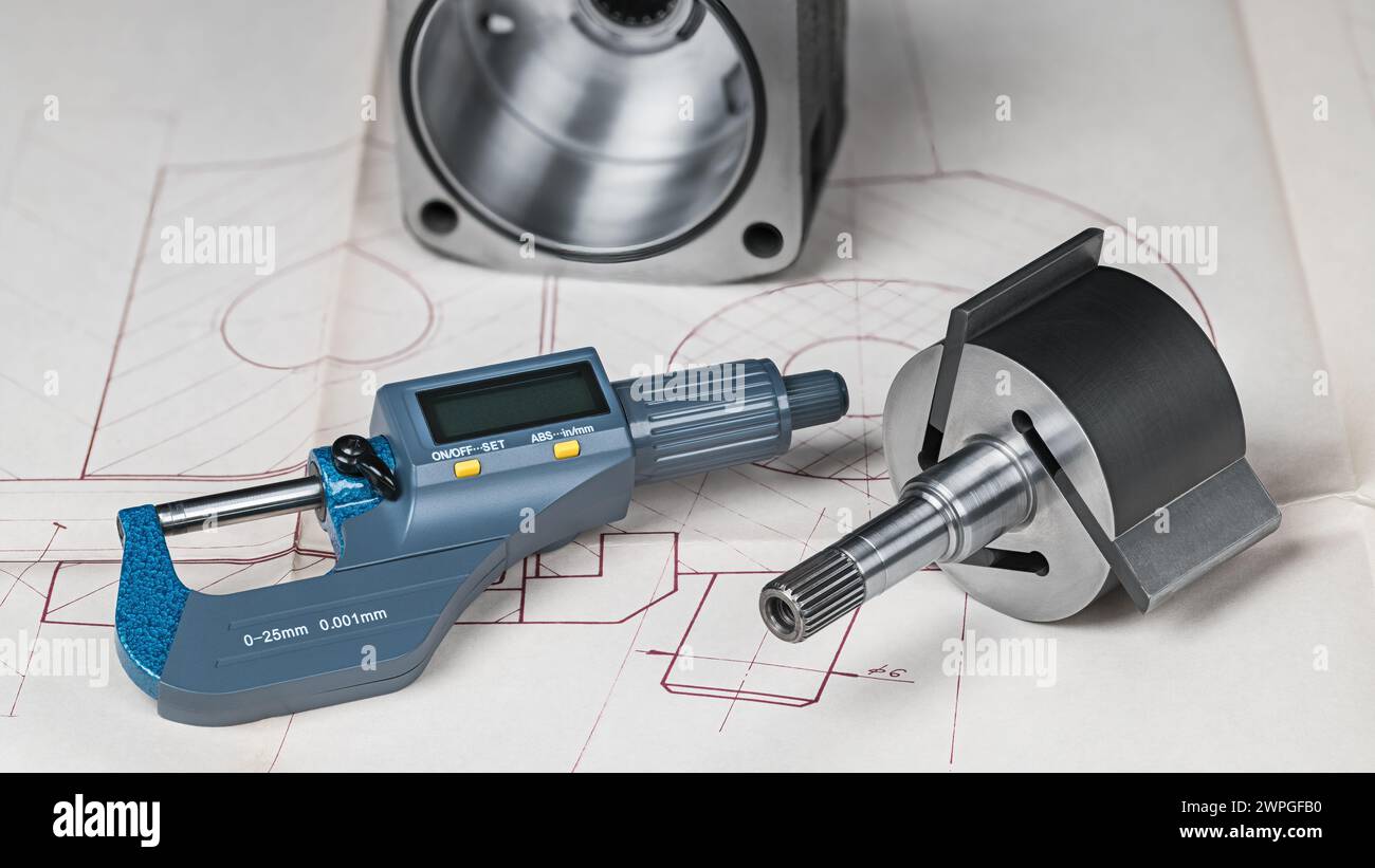 Blue micrometer screw gauge and metal parts on technical drawing ...