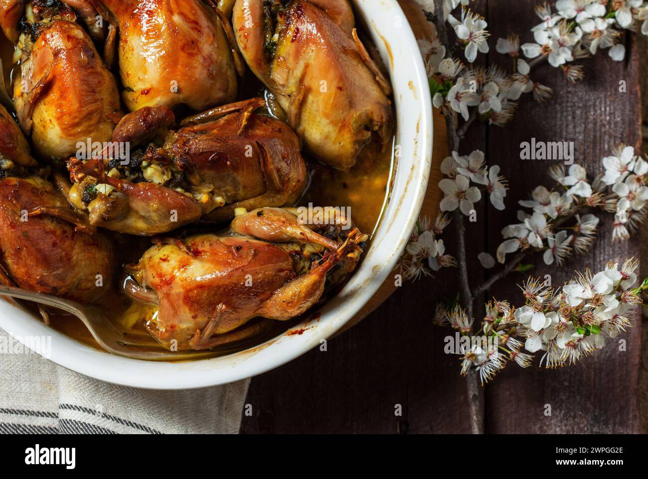 Baked quail stuffed with mushrooms, eggs and bread in a ceramic form on ...