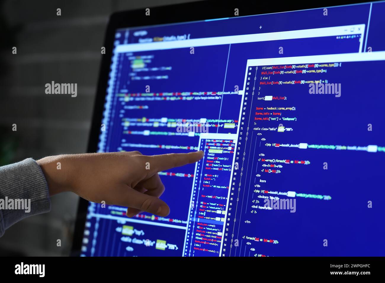 Hacker pointing at computer screen in dark room, closeup Stock Photo ...