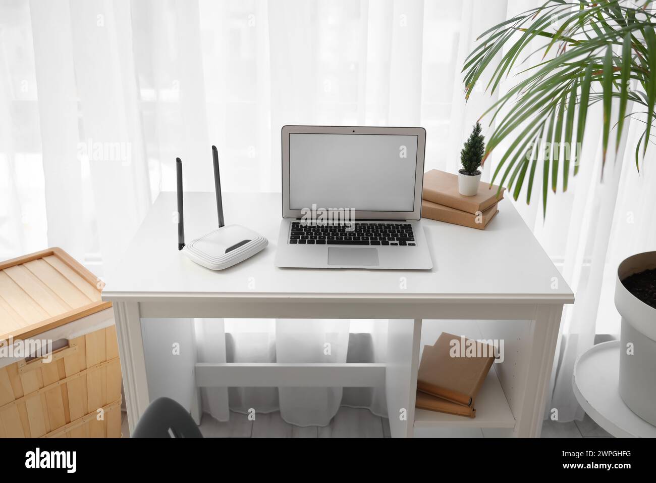 Workplace with laptop and wi-fi router in room Stock Photo - Alamy