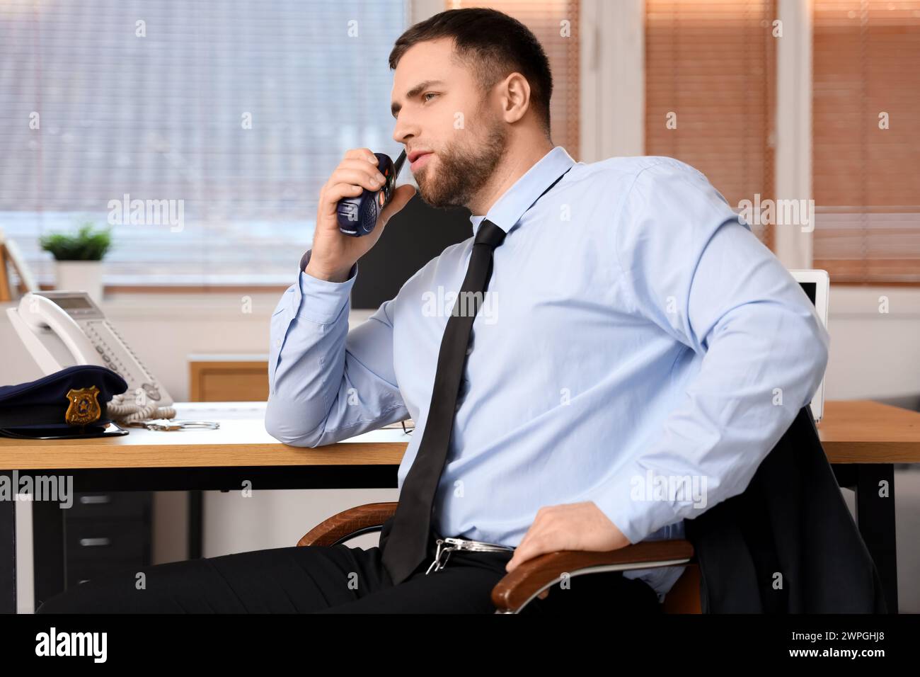 Male police officer with radio transmitter in office Stock Photo - Alamy