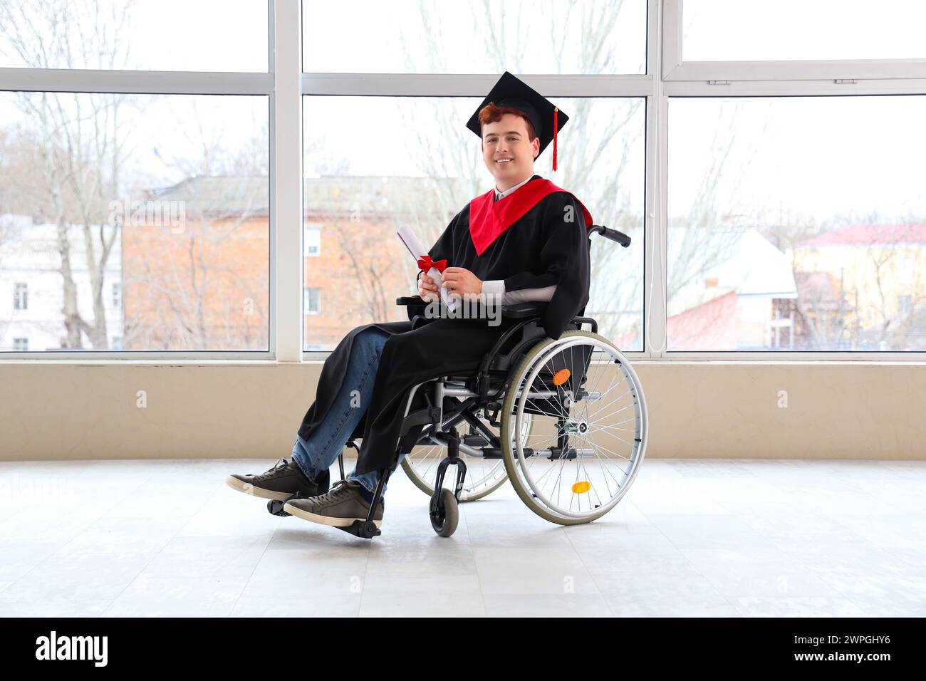 Male graduate in wheelchair with diploma at university hall Stock Photo ...