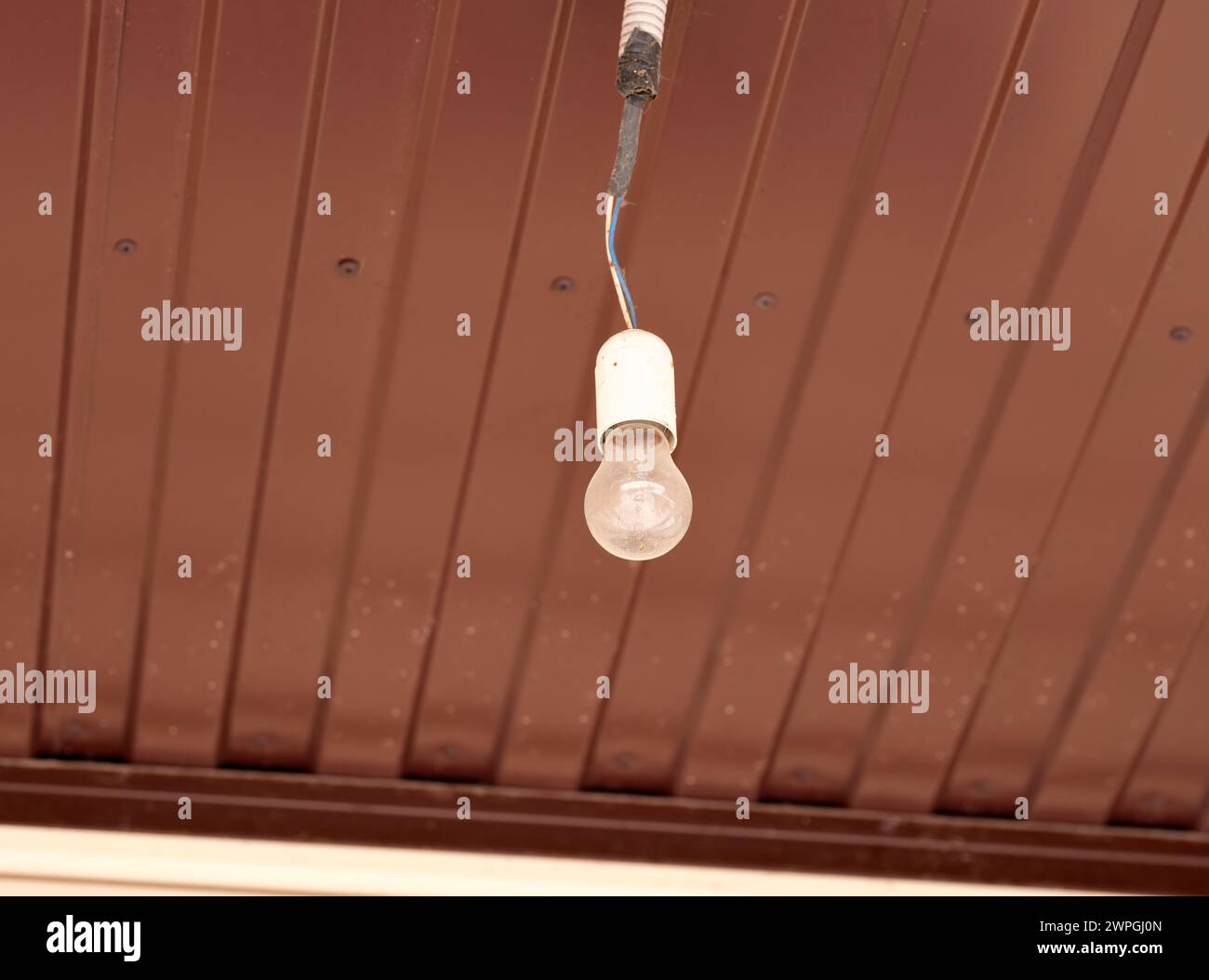 A dusty light bulb hanging from a ceiling Stock Photo - Alamy
