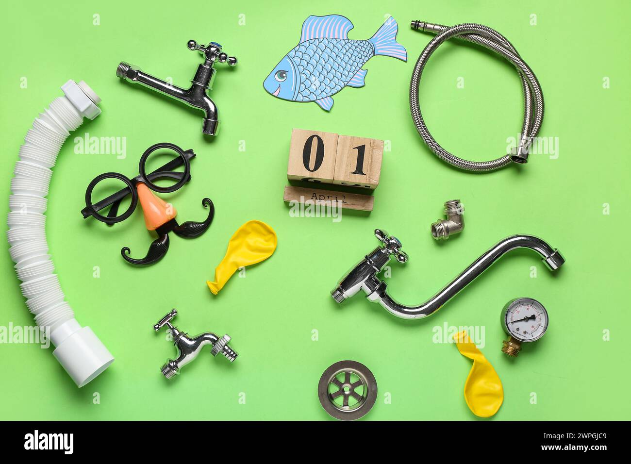 Calendar with plumber's items, funny glasses and paper fish on green ...