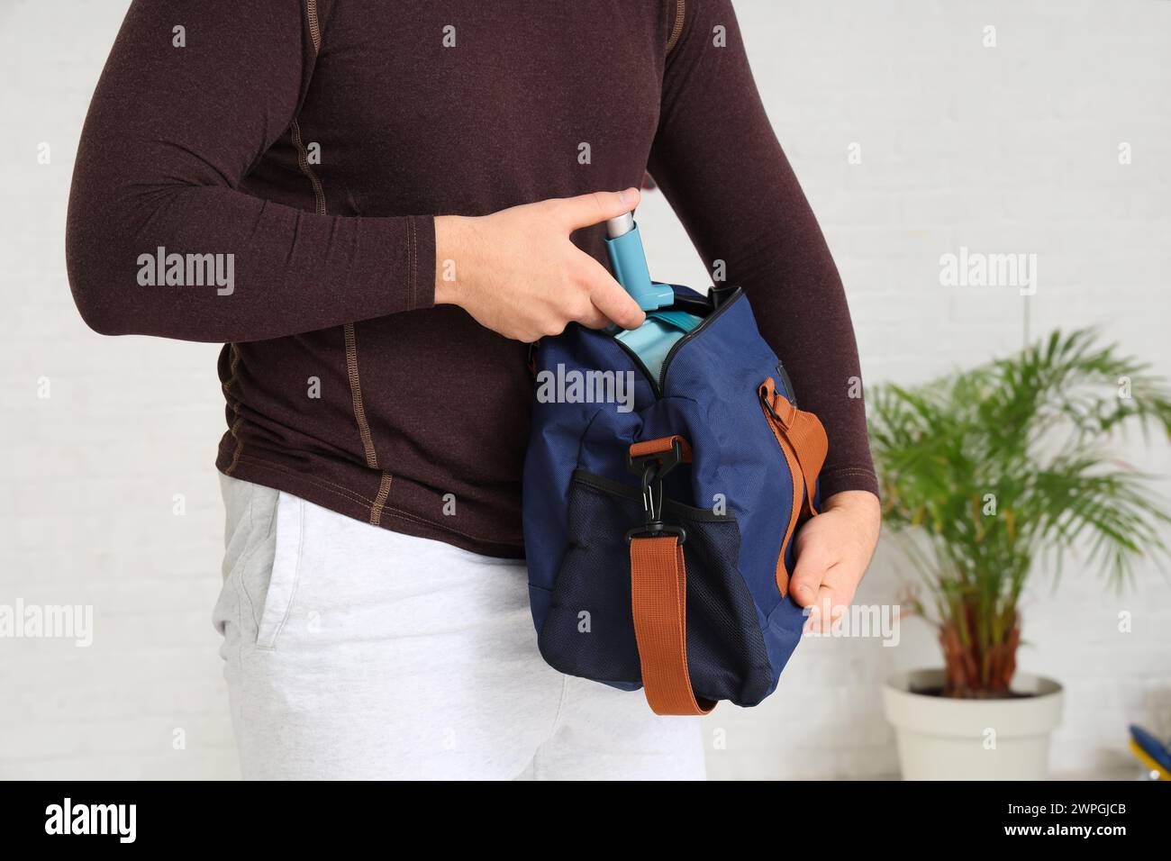 Sporty young man taking inhaler from bag in gym, closeup Stock Photo ...
