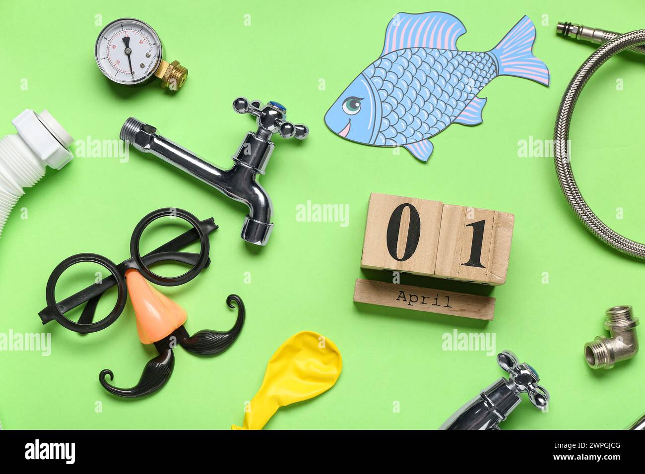 Calendar with plumber's items, funny glasses and paper fish on green ...