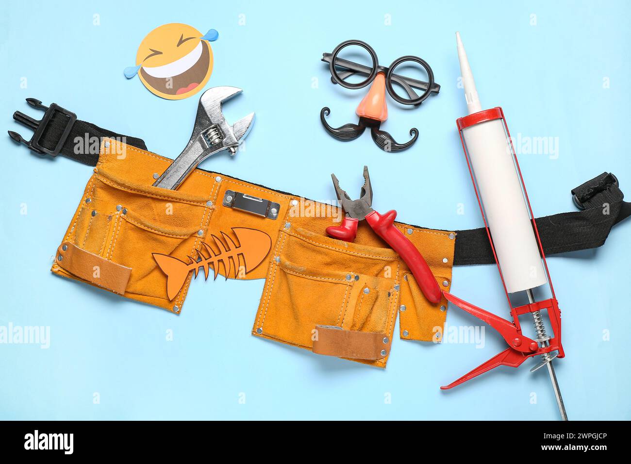 Belt with construction tools, paper fish and funny glasses on blue ...