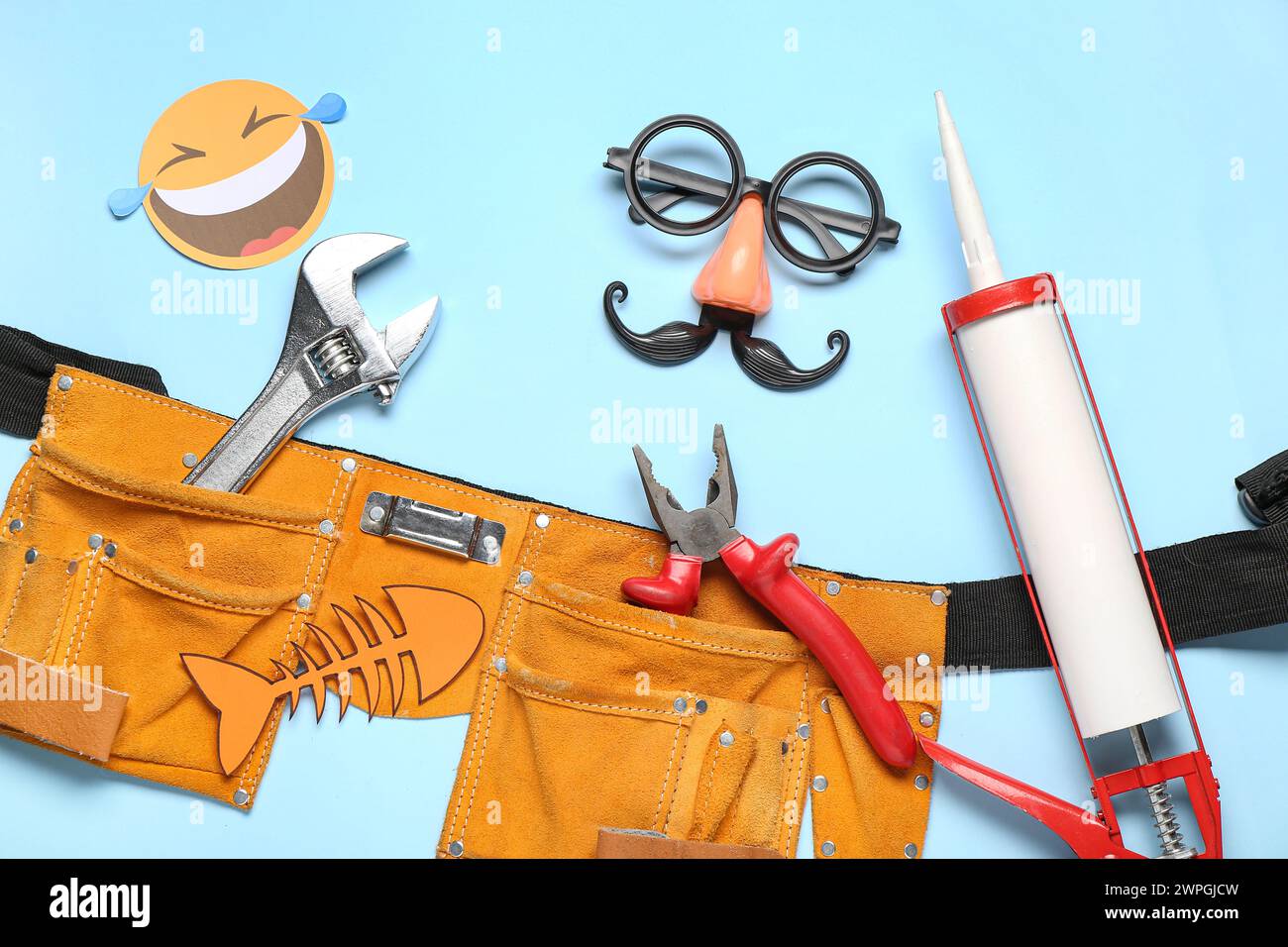 Belt with construction tools, paper fish and funny glasses on blue ...