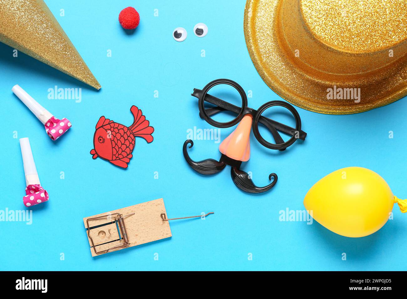 Funny glasses with paper fish, mousetrap and party decor on blue ...