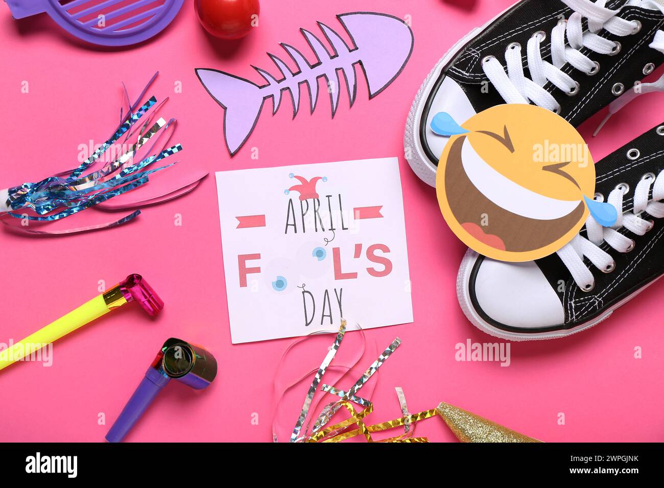 April Fool's Day card with shoes, paper fish and party decor on pink ...