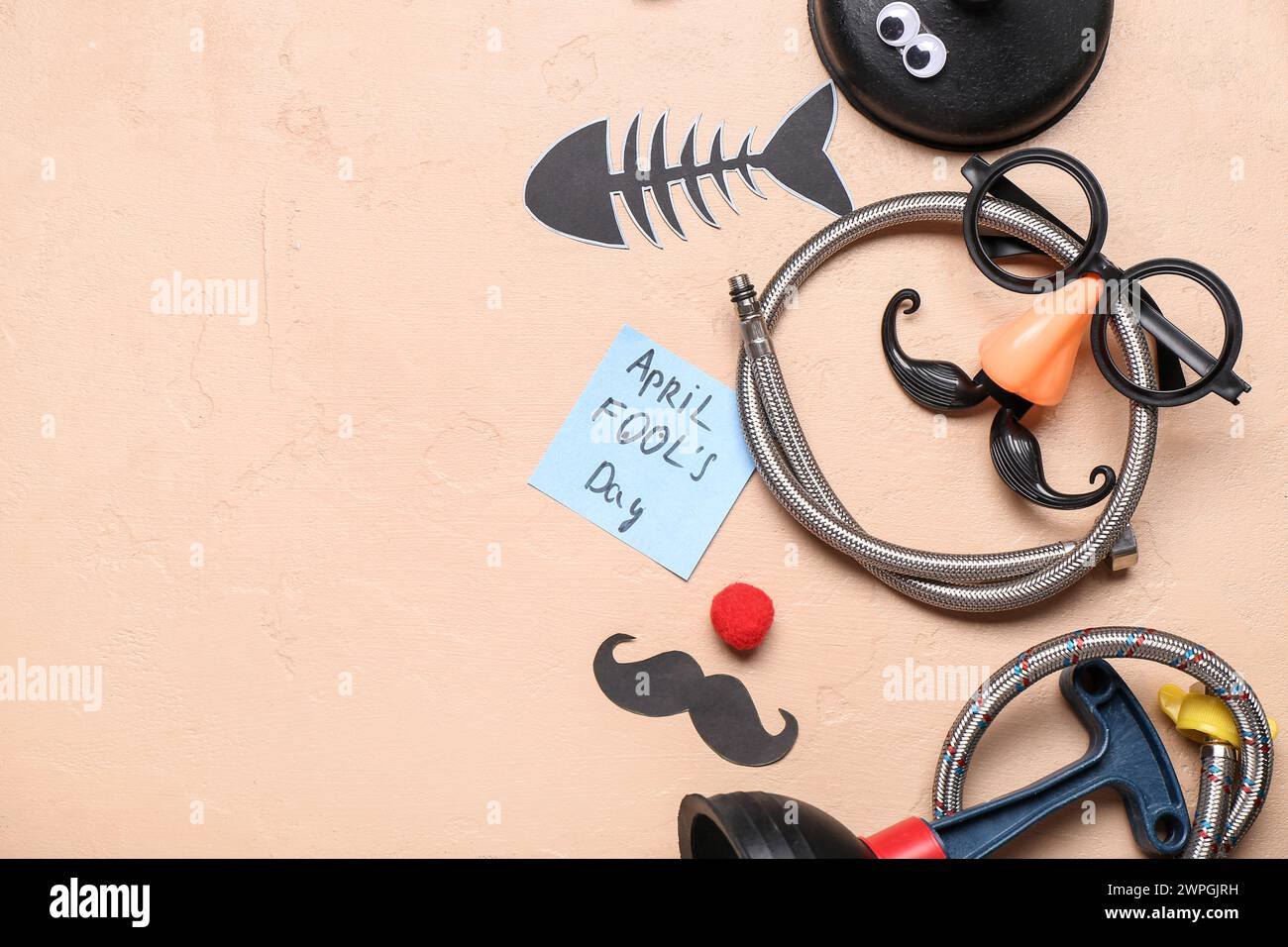 Plumber's items with funny glasses, decor and sticky note on beige ...