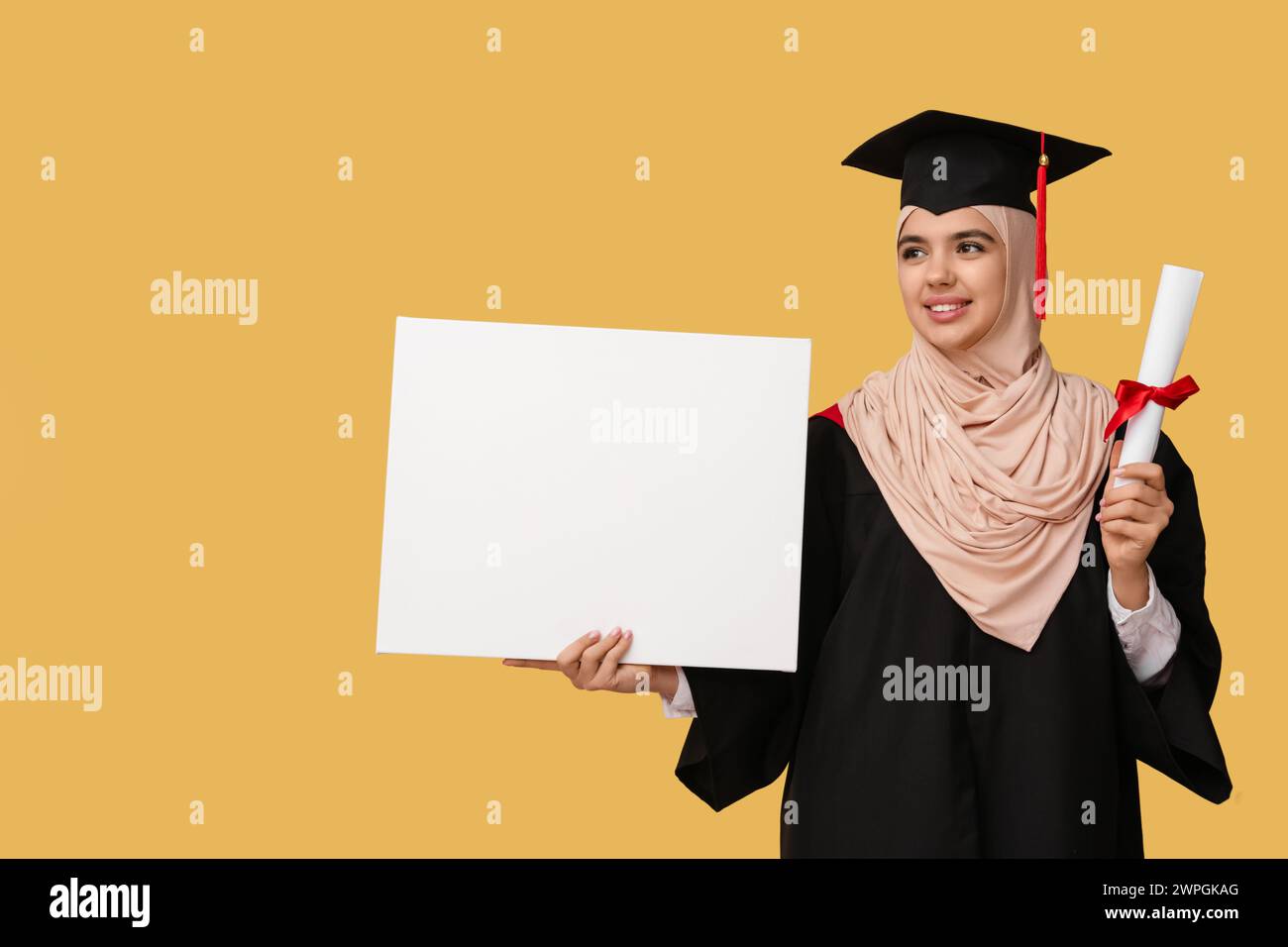 Happy Muslim female graduating student with diploma and blank poster on ...