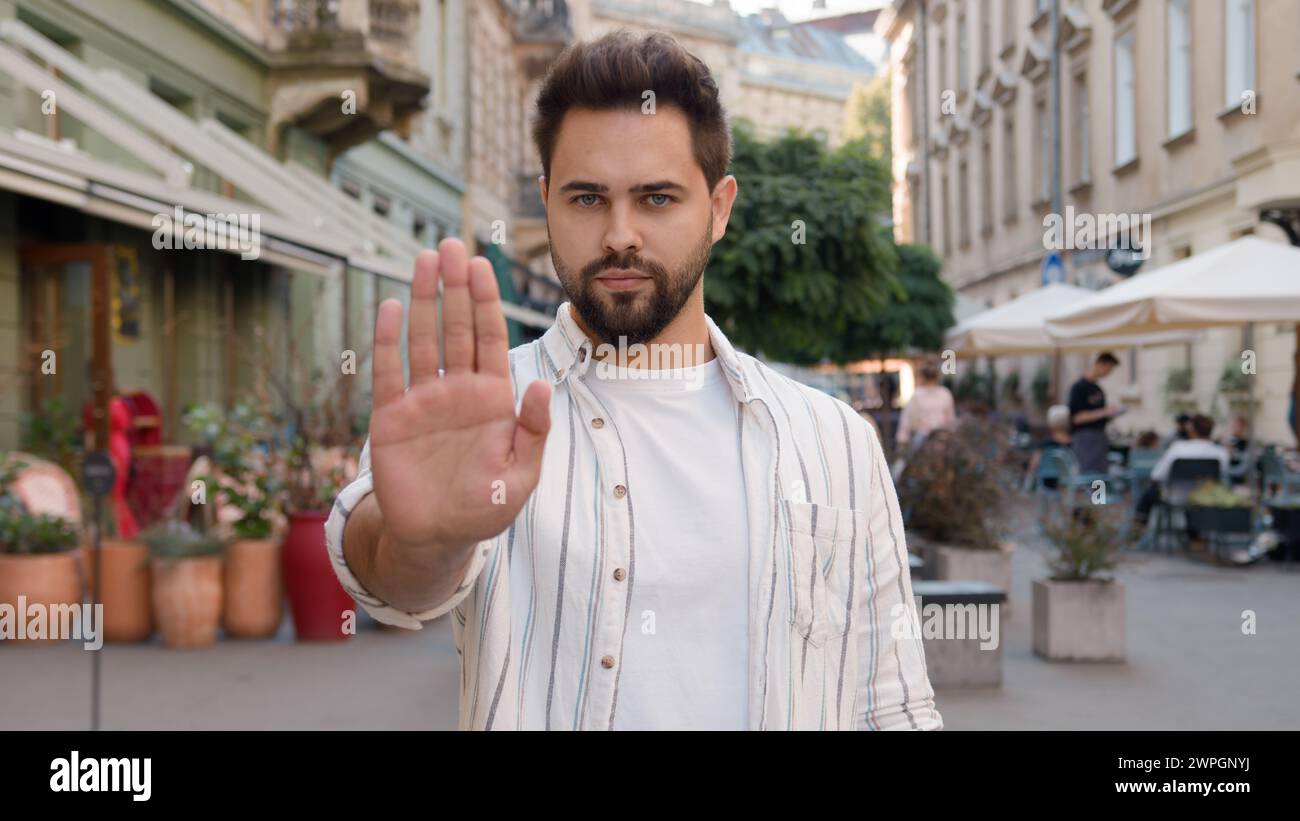 Young European Caucasian man gesture hand stop denial turn head no ...