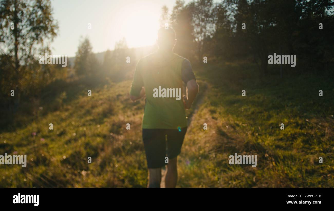 Back view sporty unrecognizable millennial Caucasian male man guy trail ...