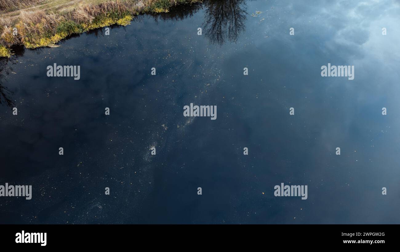 Aerial look down view on river blue reflective water surface with green ...