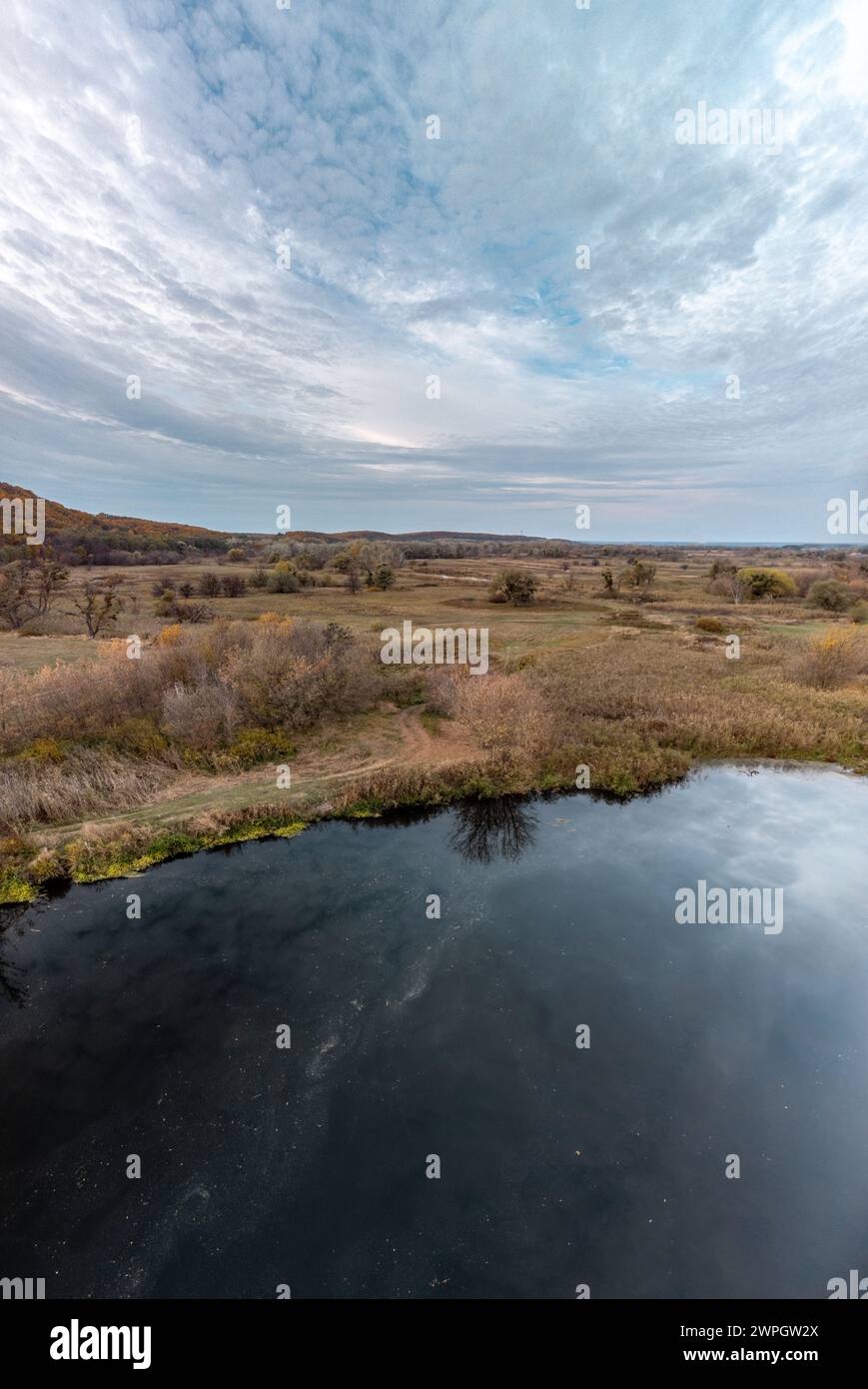 Aerial vertical panorama of river valley in autumn with blue scenic sky ...