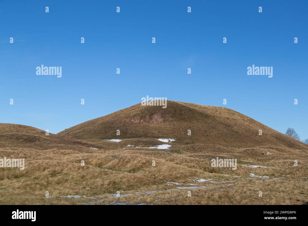 Burial mound covered with grass in rolling hill culture landscape ...
