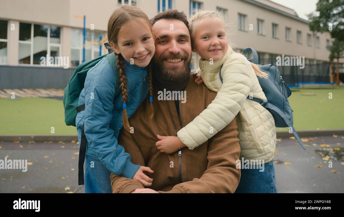 Close up European man little girls father and daughters hug sisters ...