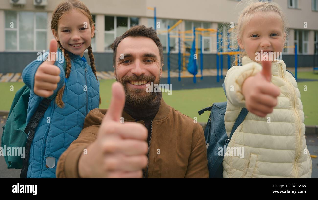 Happy European family dad daughters show thumbs up smile cheerful man ...