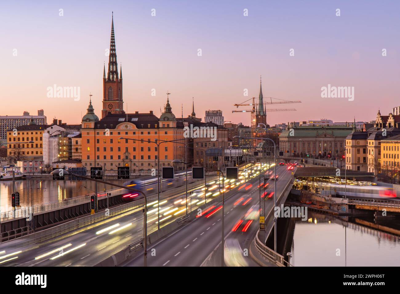 Sunset over Stockholm old town, light trails of cars, metro and train ...