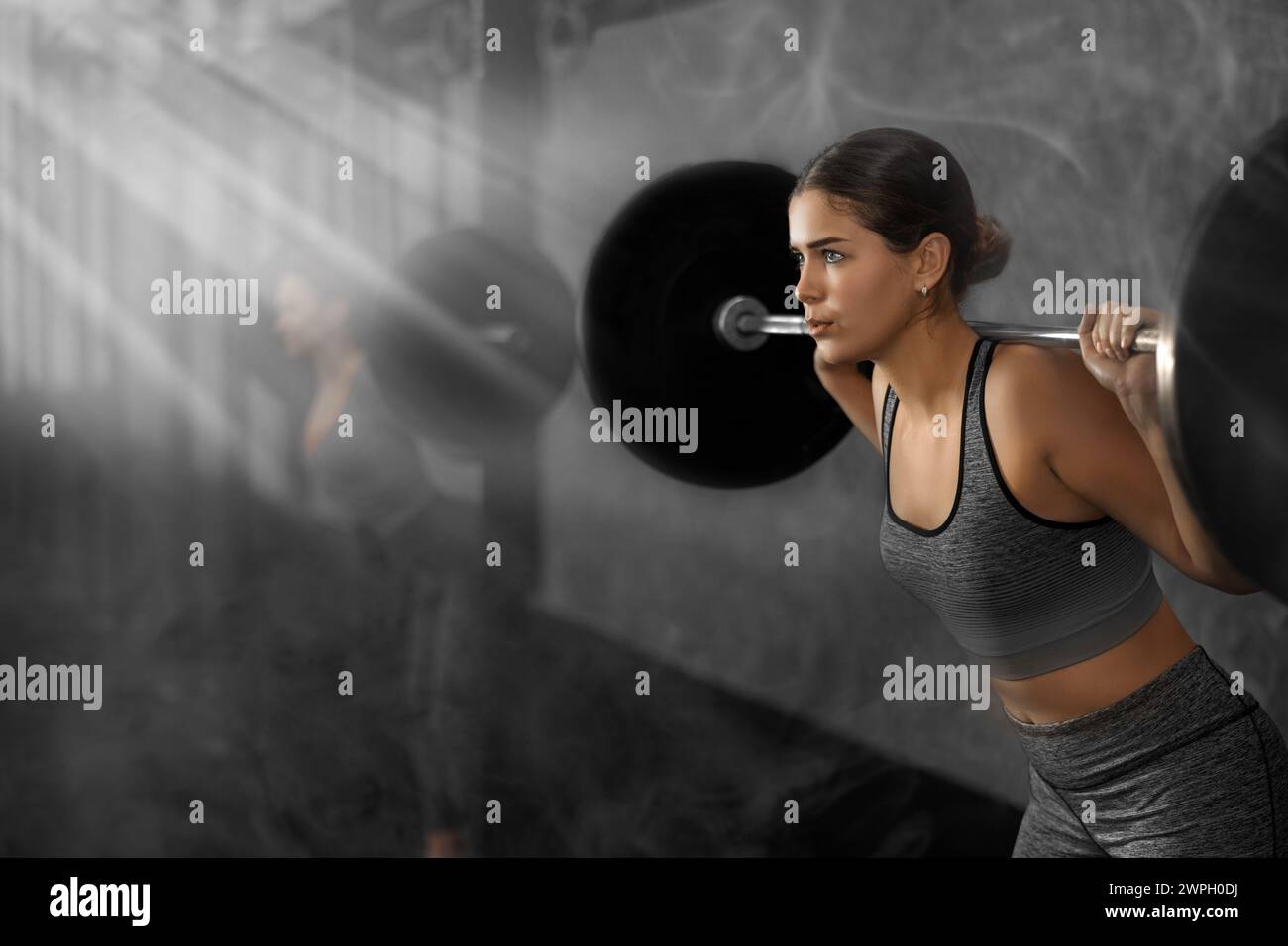 Slender girl trains muscles of arms and back using barbell and ...