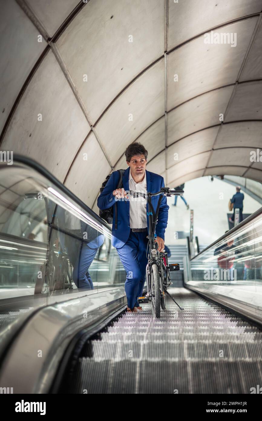 vertical portrait A businessman is seen ascending the metro escalator ...