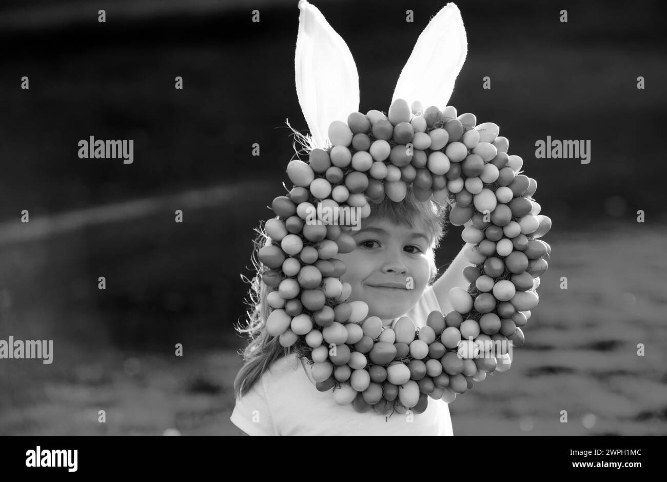 Child boy with easter eggs and bunny ears outdoor. Cute kid having ...