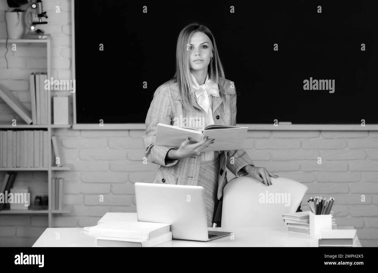 Female student preparing exam and learning lessons in school classroom ...