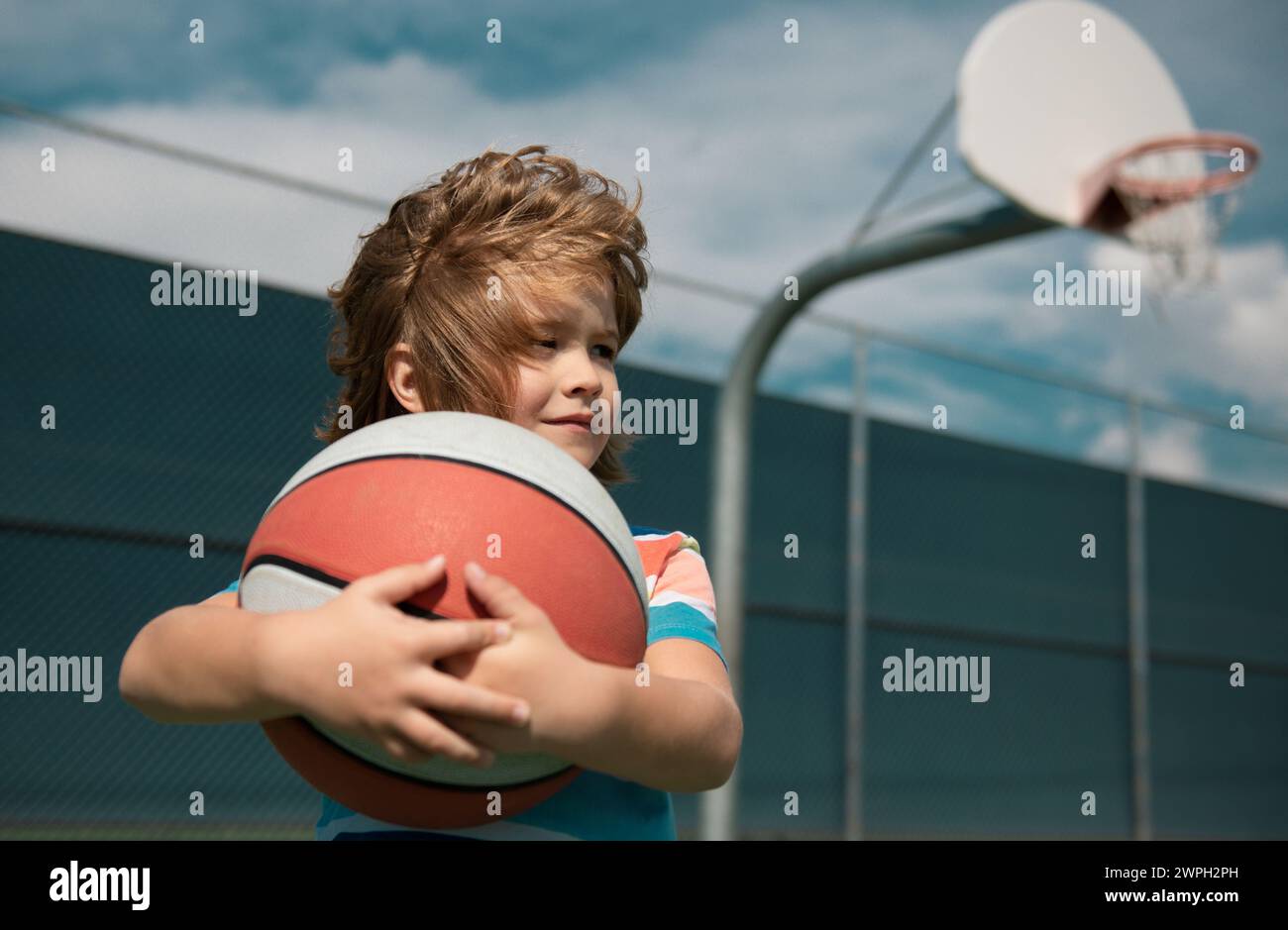 Kid playing basketball. Little caucasian sports kid playing basketball ...