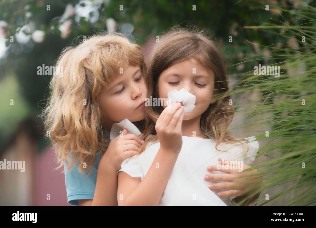 Child boy and girl hugging each other with love in the spring garden ...
