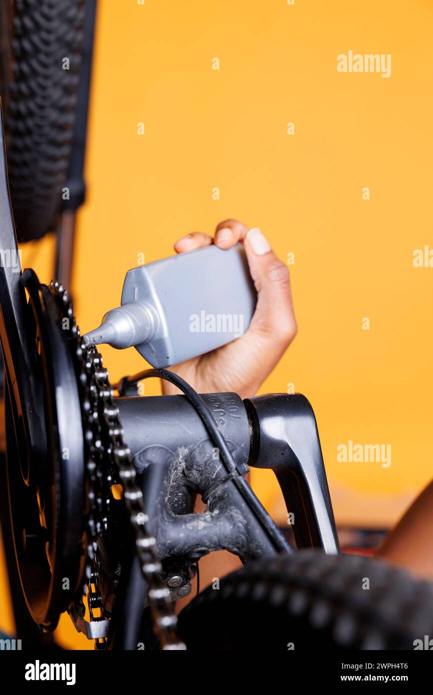 Close-up shot showcases female hand holding bike oil for ensuring top ...
