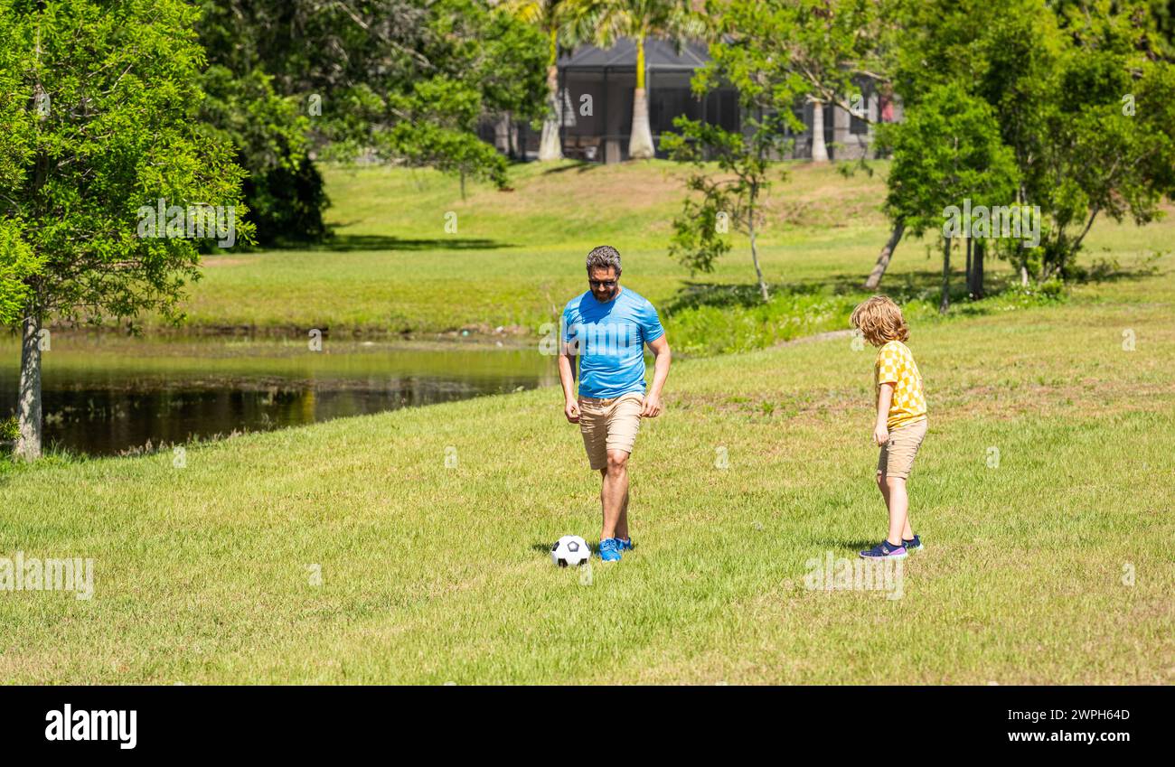 Father dad and son enjoying outdoor activities together. kicking soccer ...
